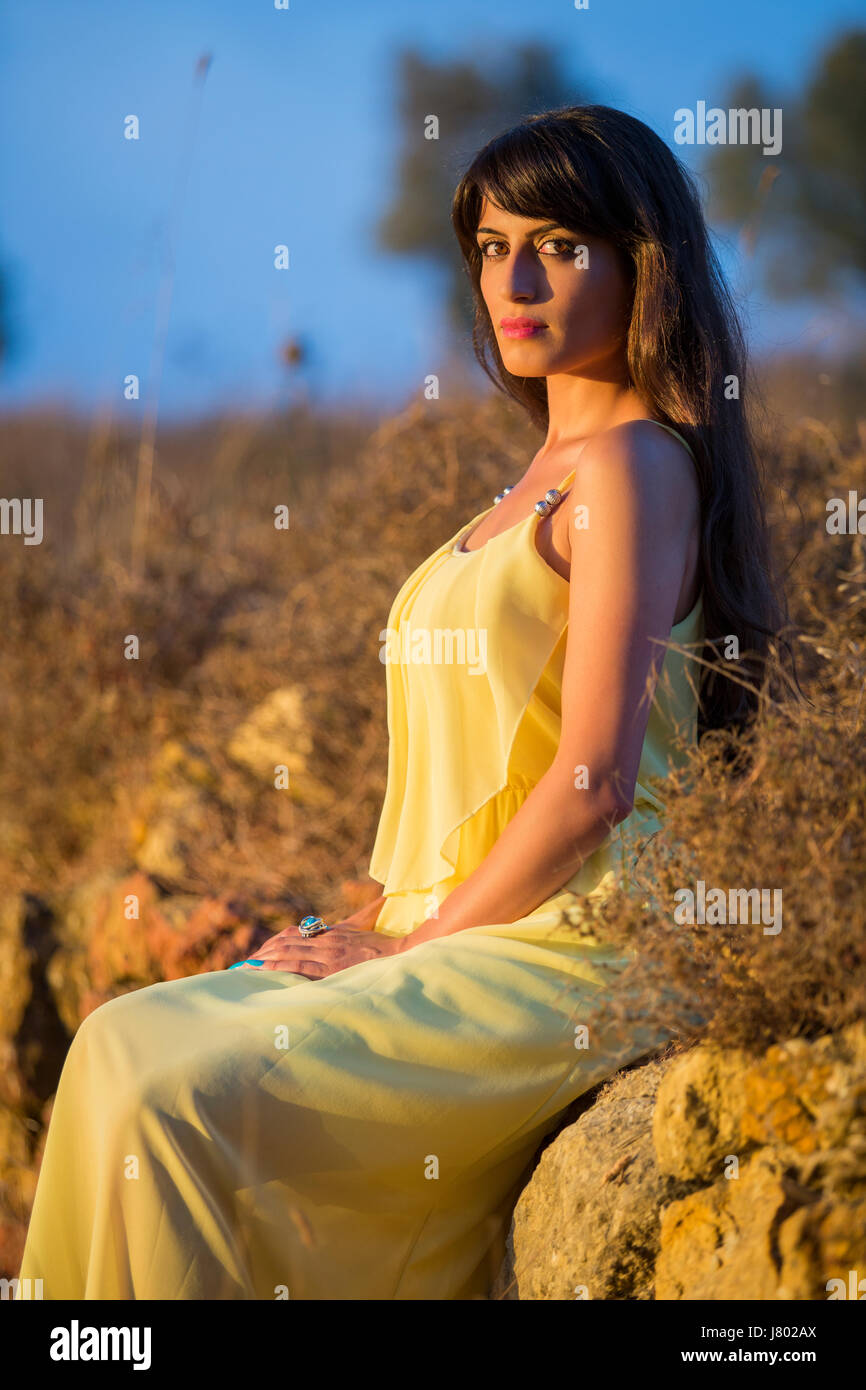 Serious woman sitting alone outdoors Stock Photo - Alamy