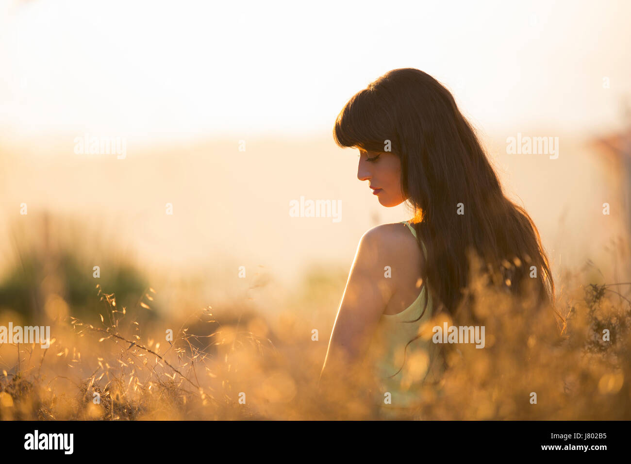 Sad young woman outdoors at sunset Stock Photo - Alamy
