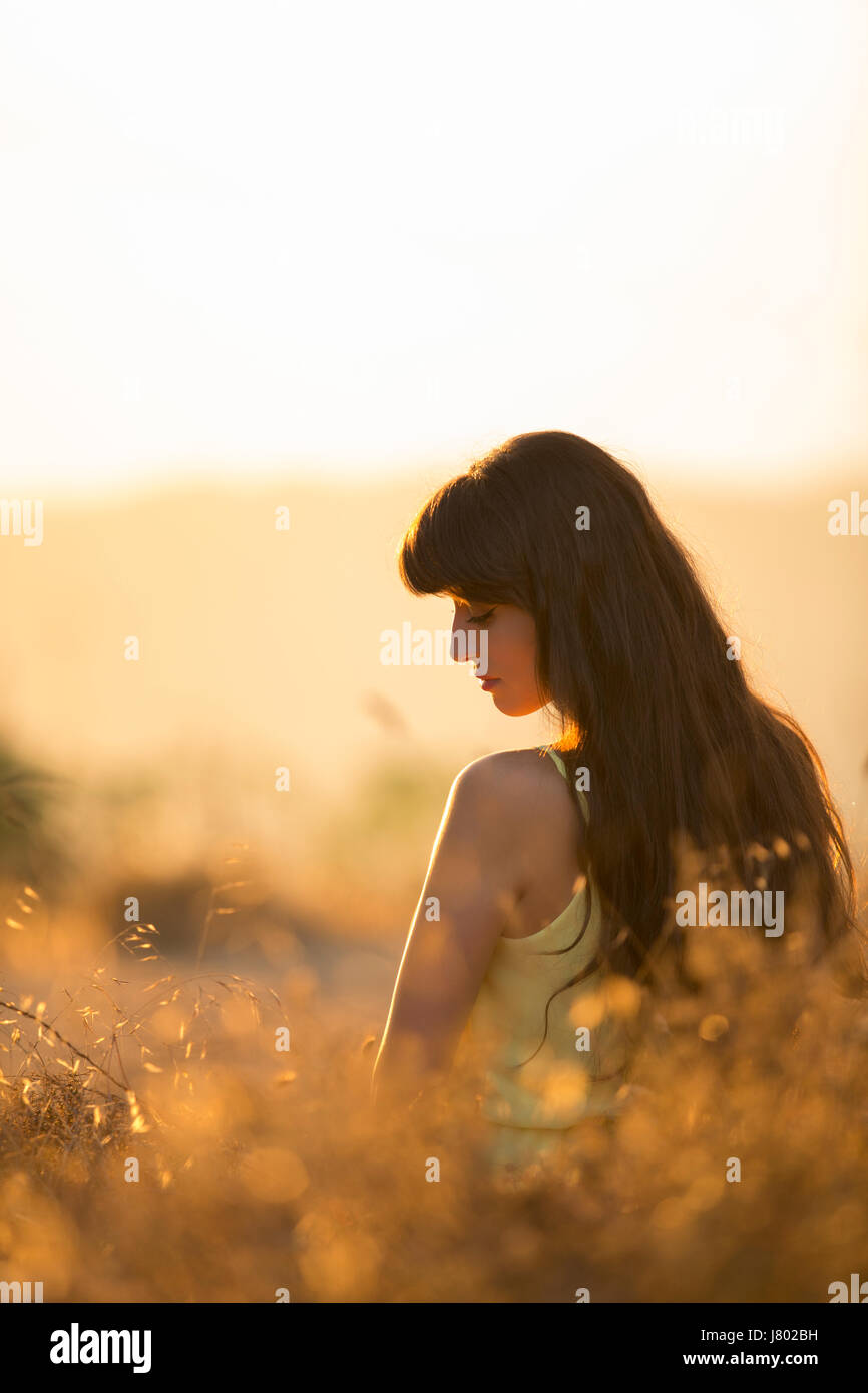 Sad young woman outdoors at sunset Stock Photo - Alamy