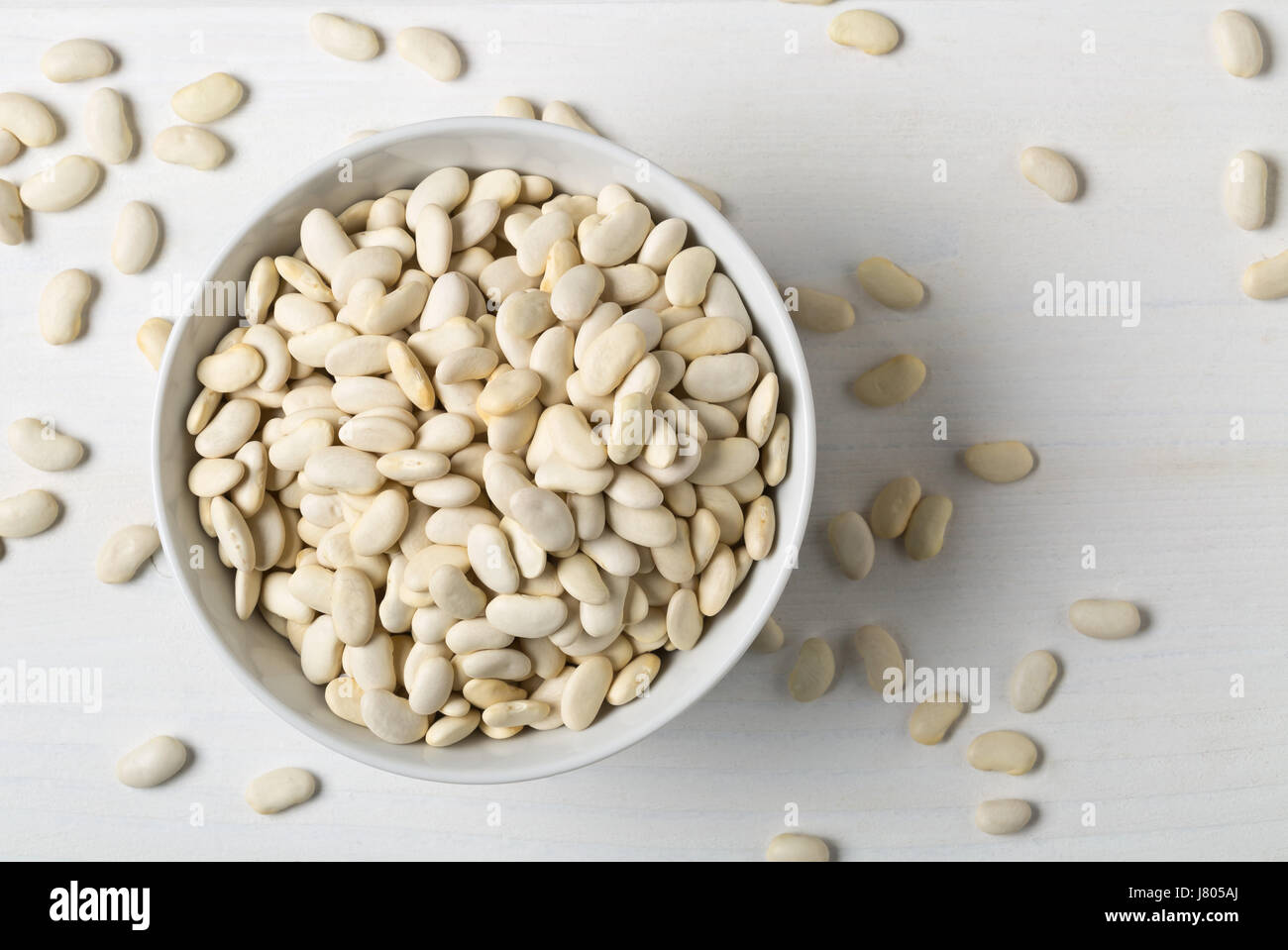 Dried white bean legumes in white bowl on white table background Stock ...