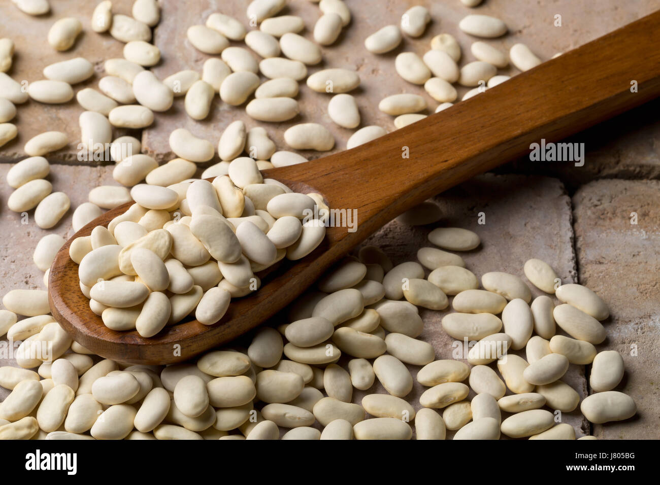 Dried white bean legumes in wooden scoop on stone background Stock ...