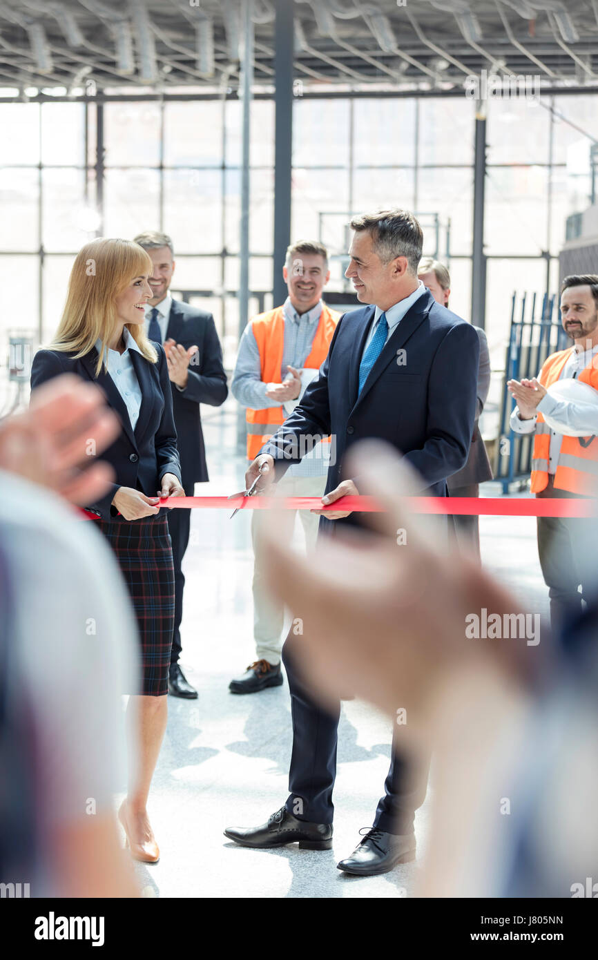 Business people cutting ribbon at new construction site ceremony Stock ...
