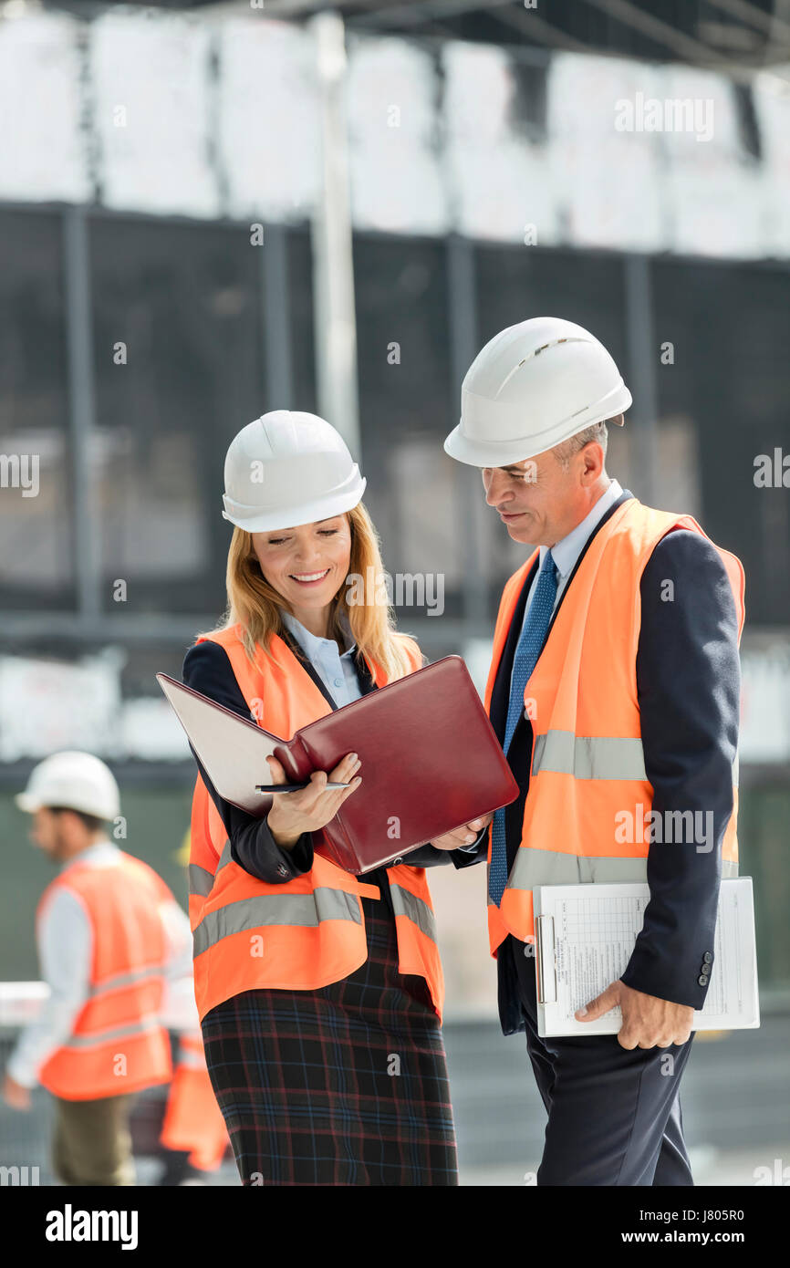 Architects reviewing paperwork at construction site Stock Photo - Alamy