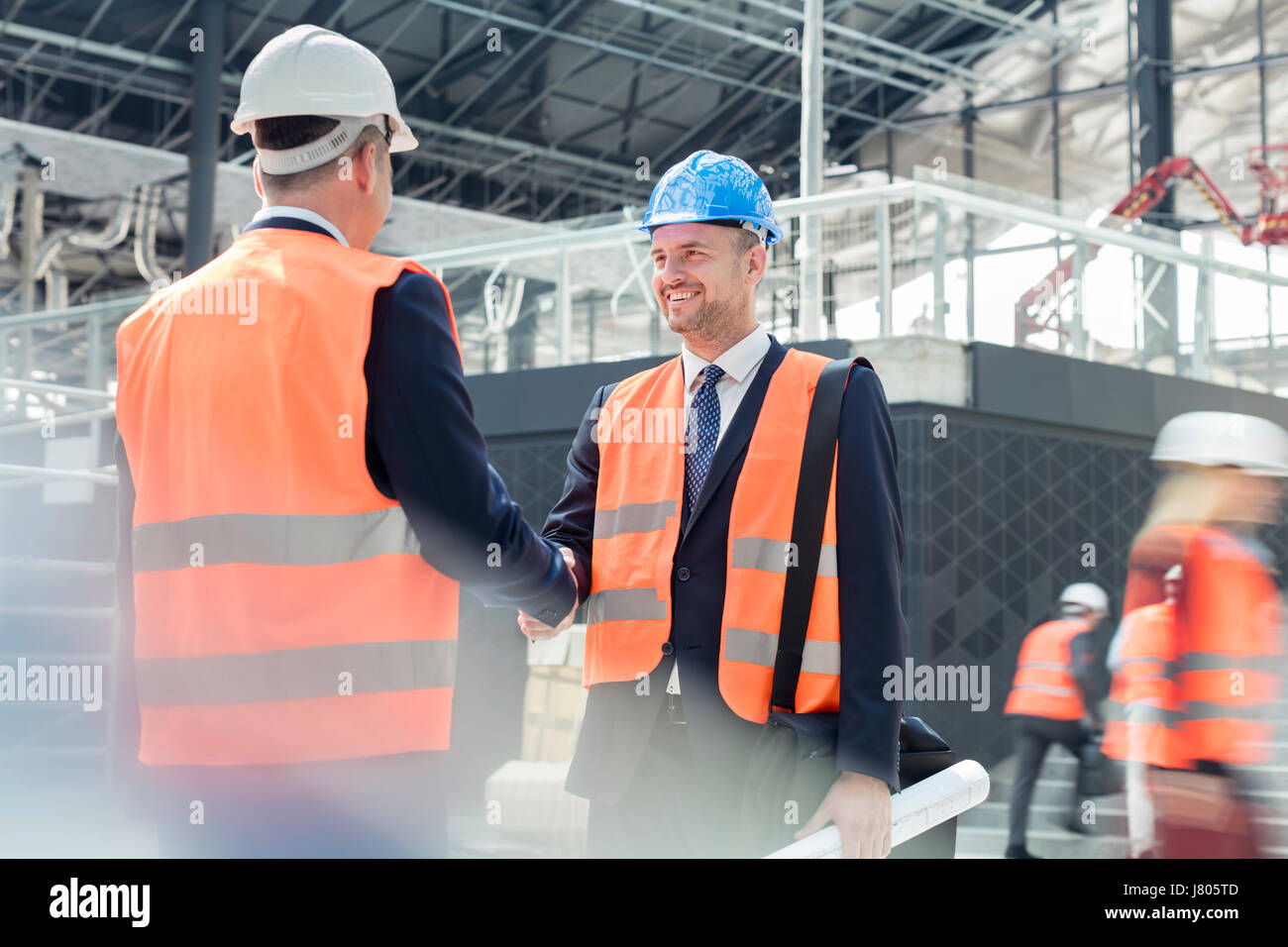 Male engineers handshaking at construction site Stock Photo - Alamy