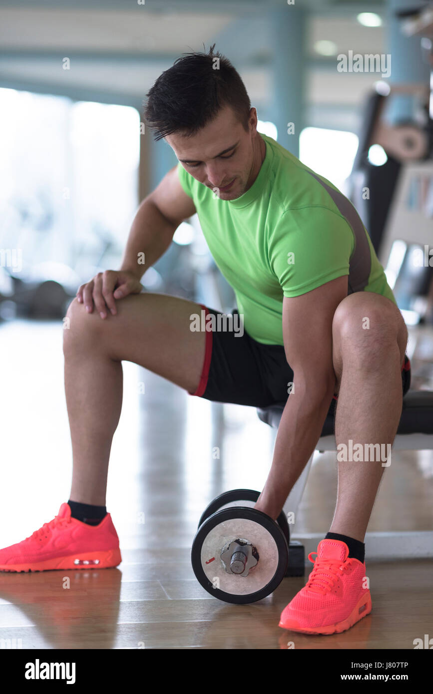 young handsome man working out with dumbbells in a fitness gym Stock ...