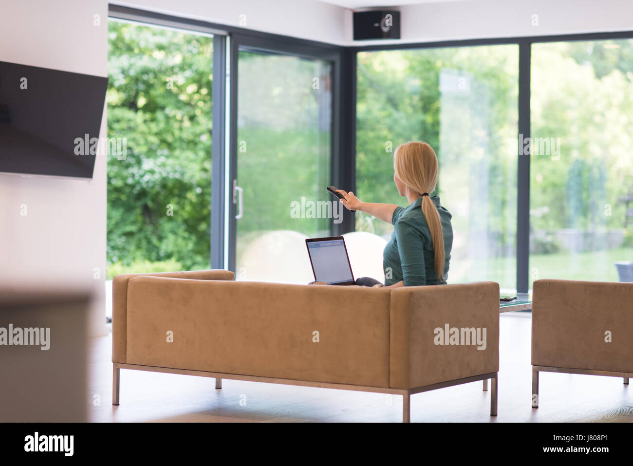 Young woman using her laptop computer in her luxury modern home ...