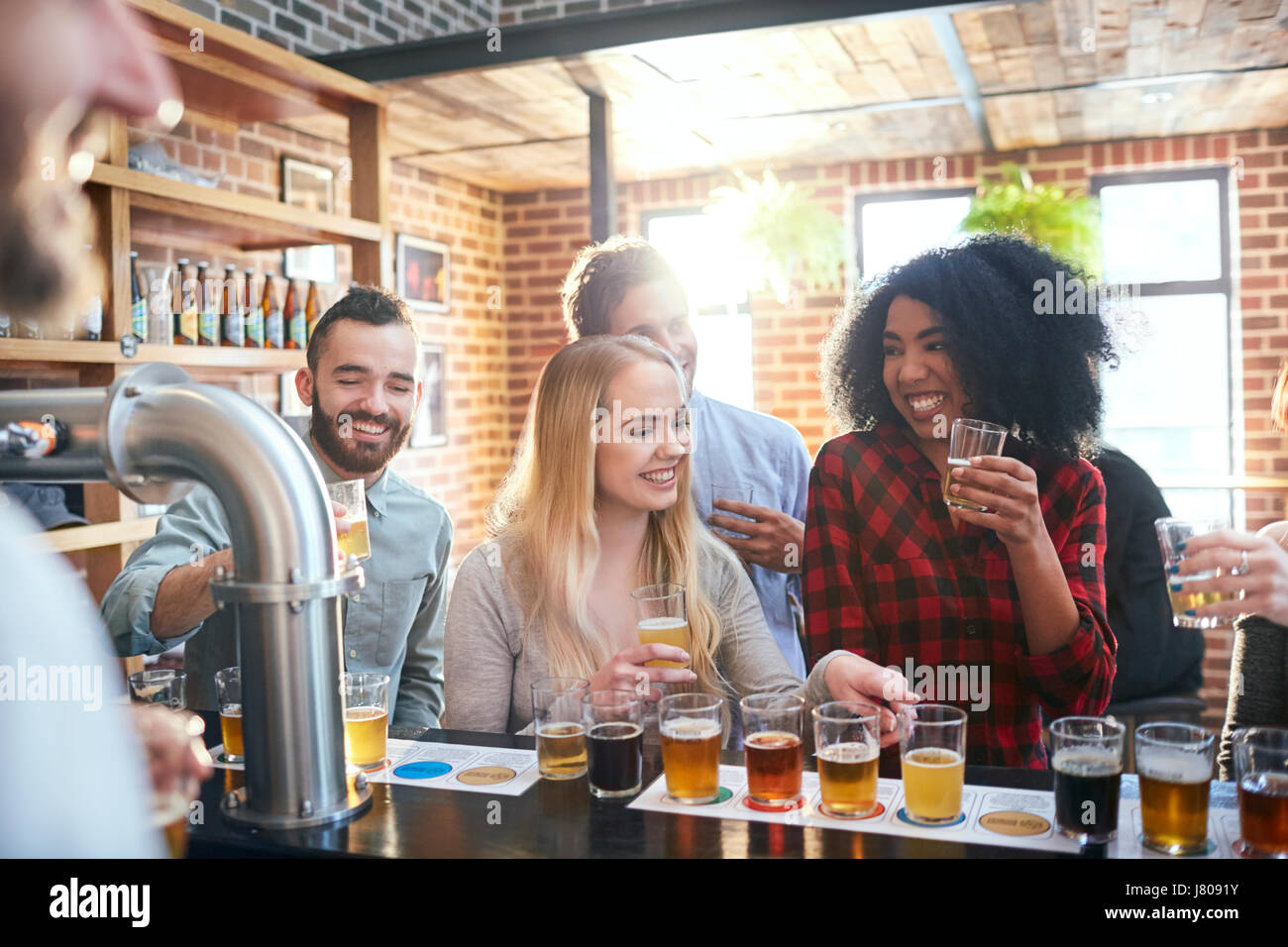 Friends sampling, drinking beer in pub Stock Photo - Alamy