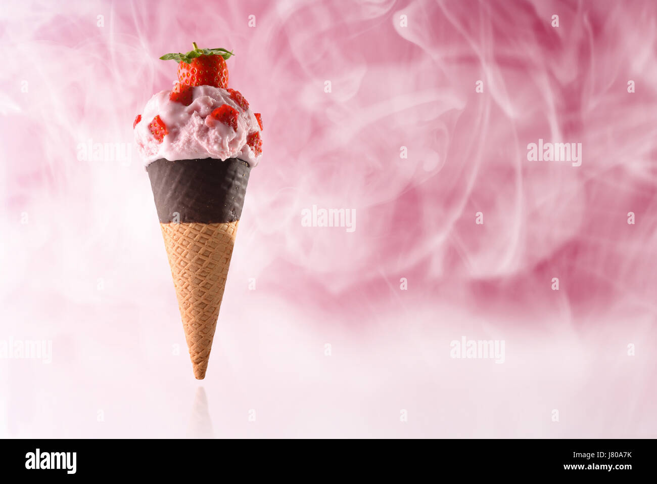 Ice cream cone flavored strawberry. Elevated on reflective table and ...