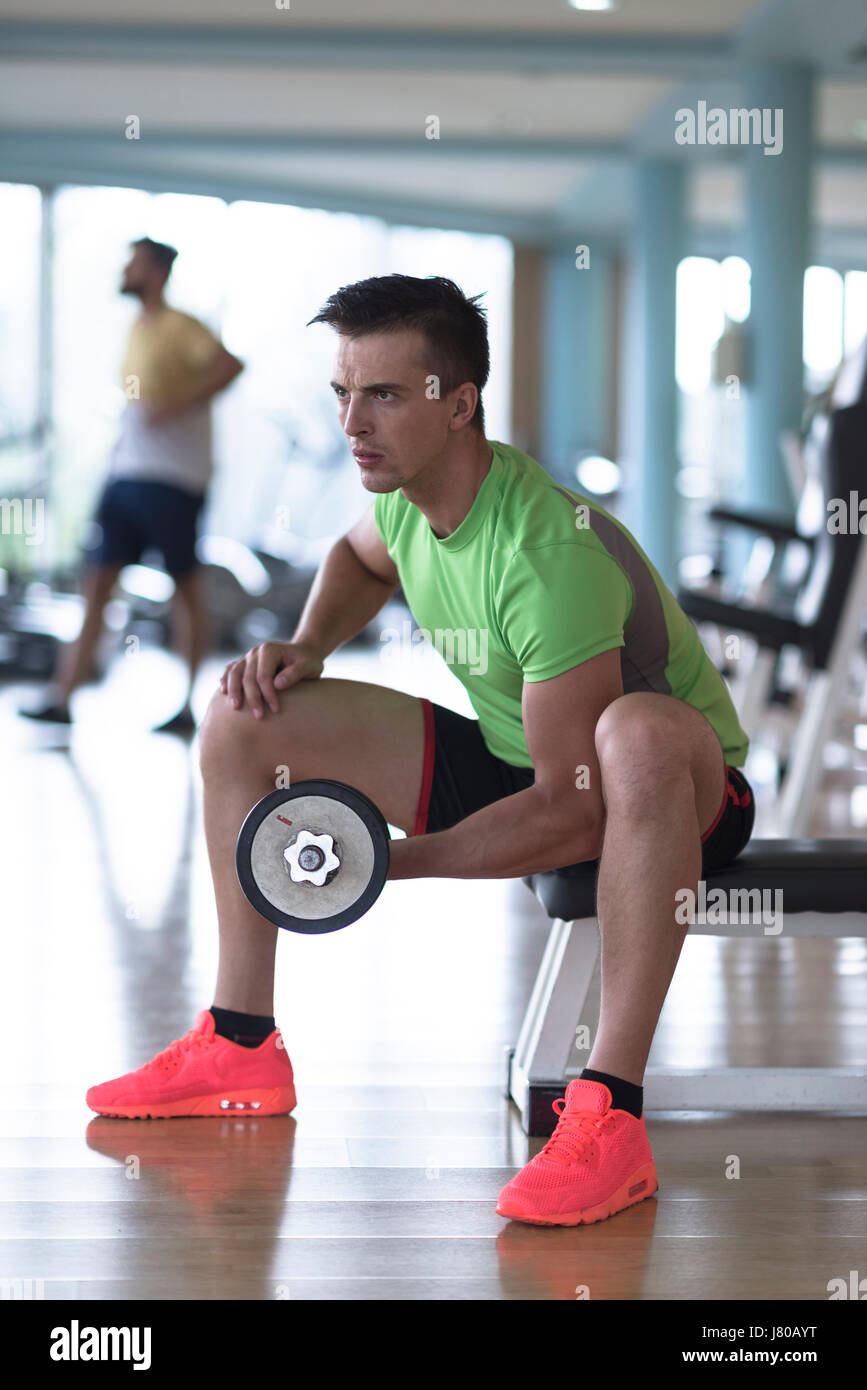 young handsome man working out with dumbbells in a fitness gym Stock ...
