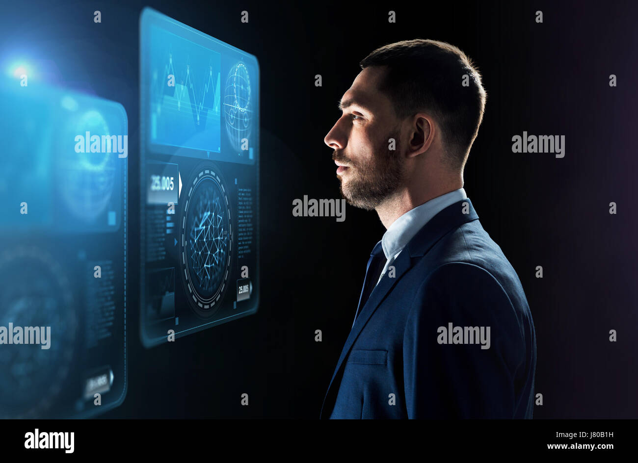 businessman looking at virtual screens over black Stock Photo - Alamy