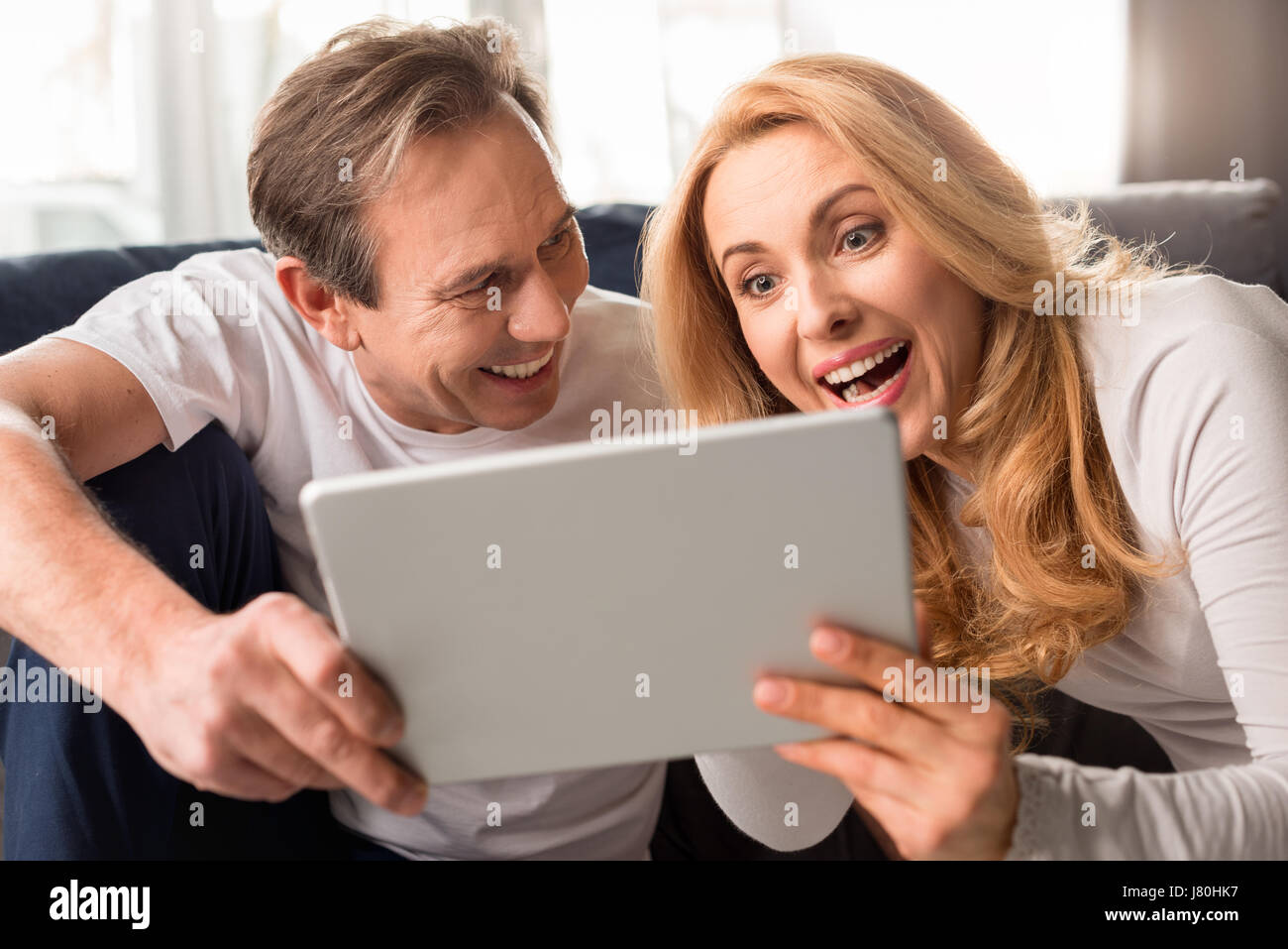 Happy middle aged couple using digital tablet at home Stock Photo - Alamy
