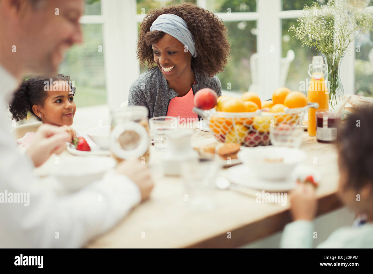 Multi-ethnic young family eating breakfast at table Stock Photo - Alamy