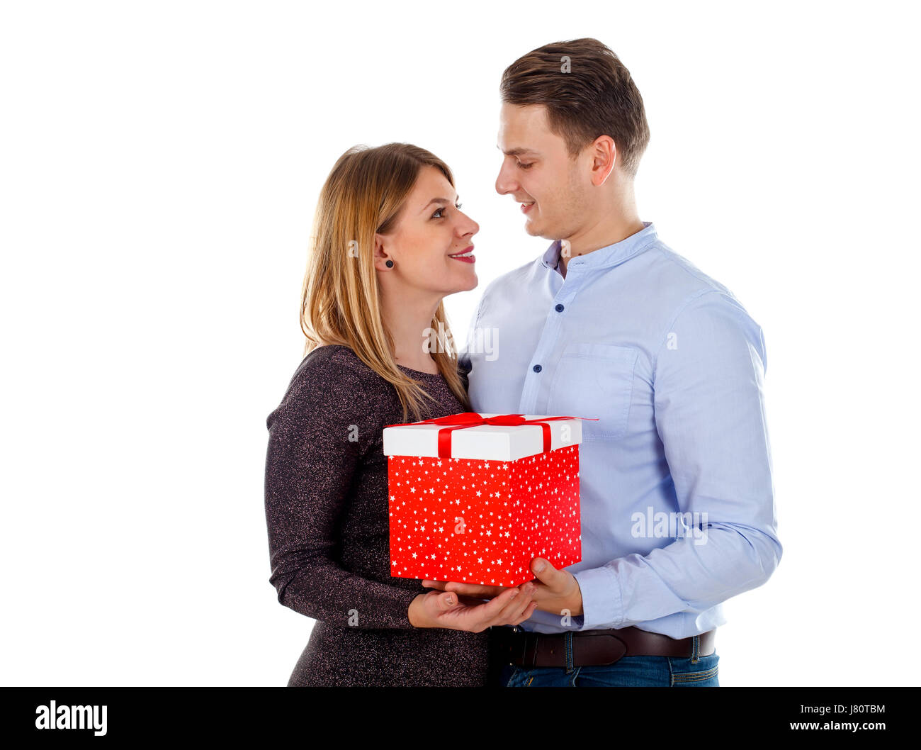 Picture of an attentive man giving a surprise-gift to his girlfriend ...