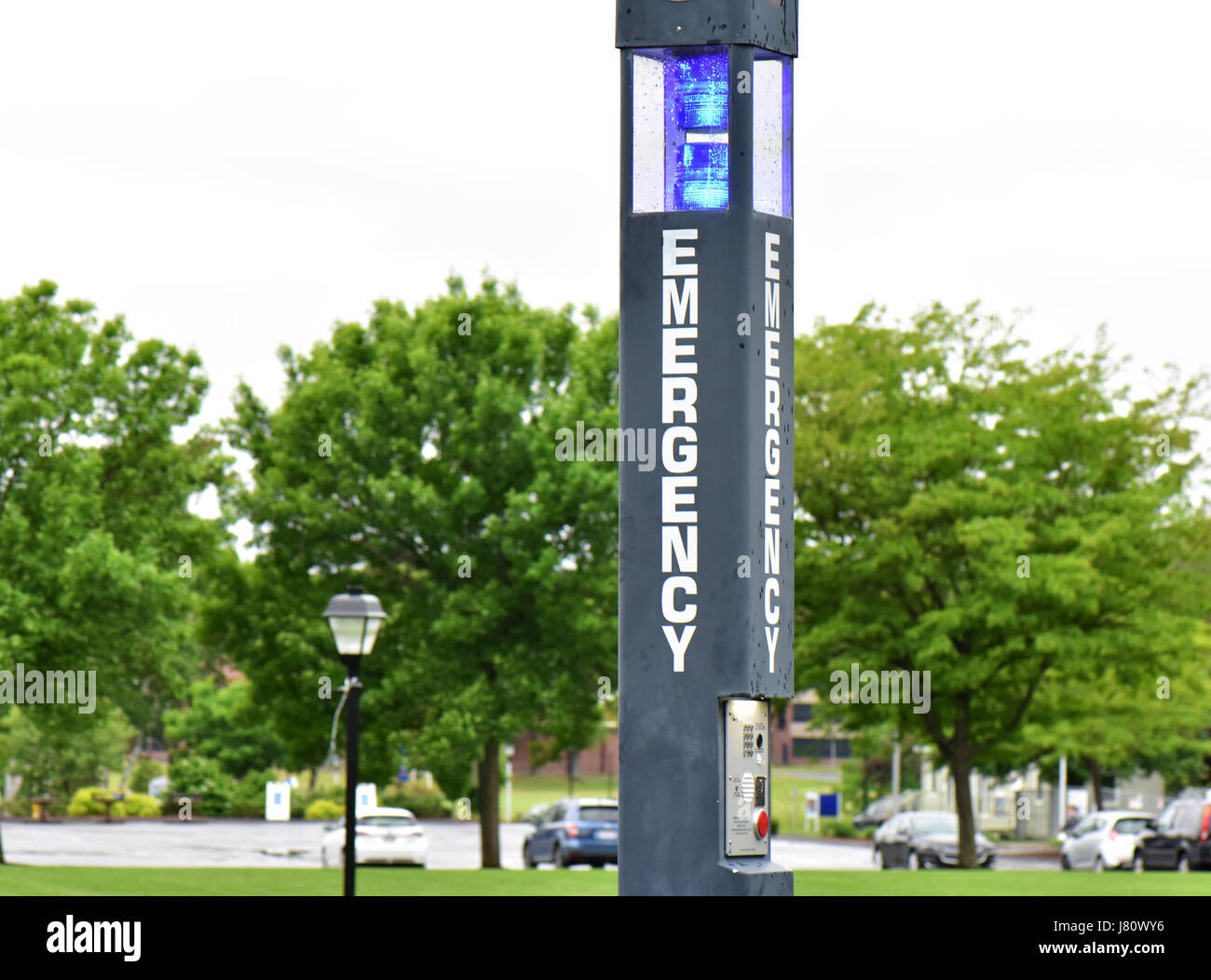 In the foreground a blue-light pole on a college campus in New England ...