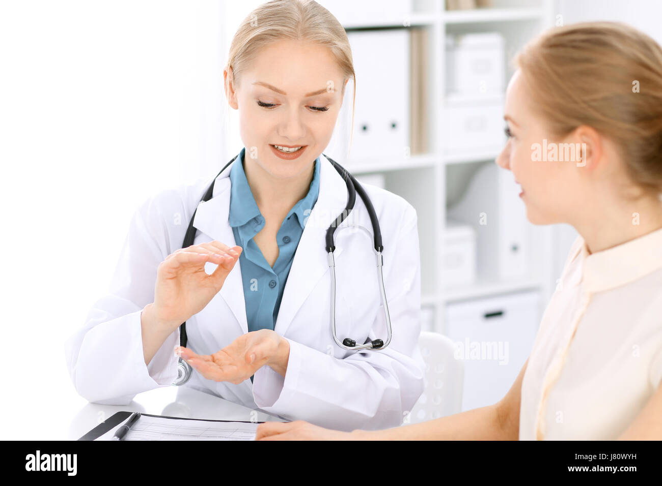 Doctor and patient sitting at the desk Stock Photo - Alamy