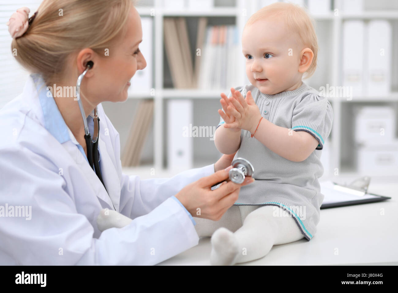 Pediatrician is taking care of baby in hospital. Little girl is being ...