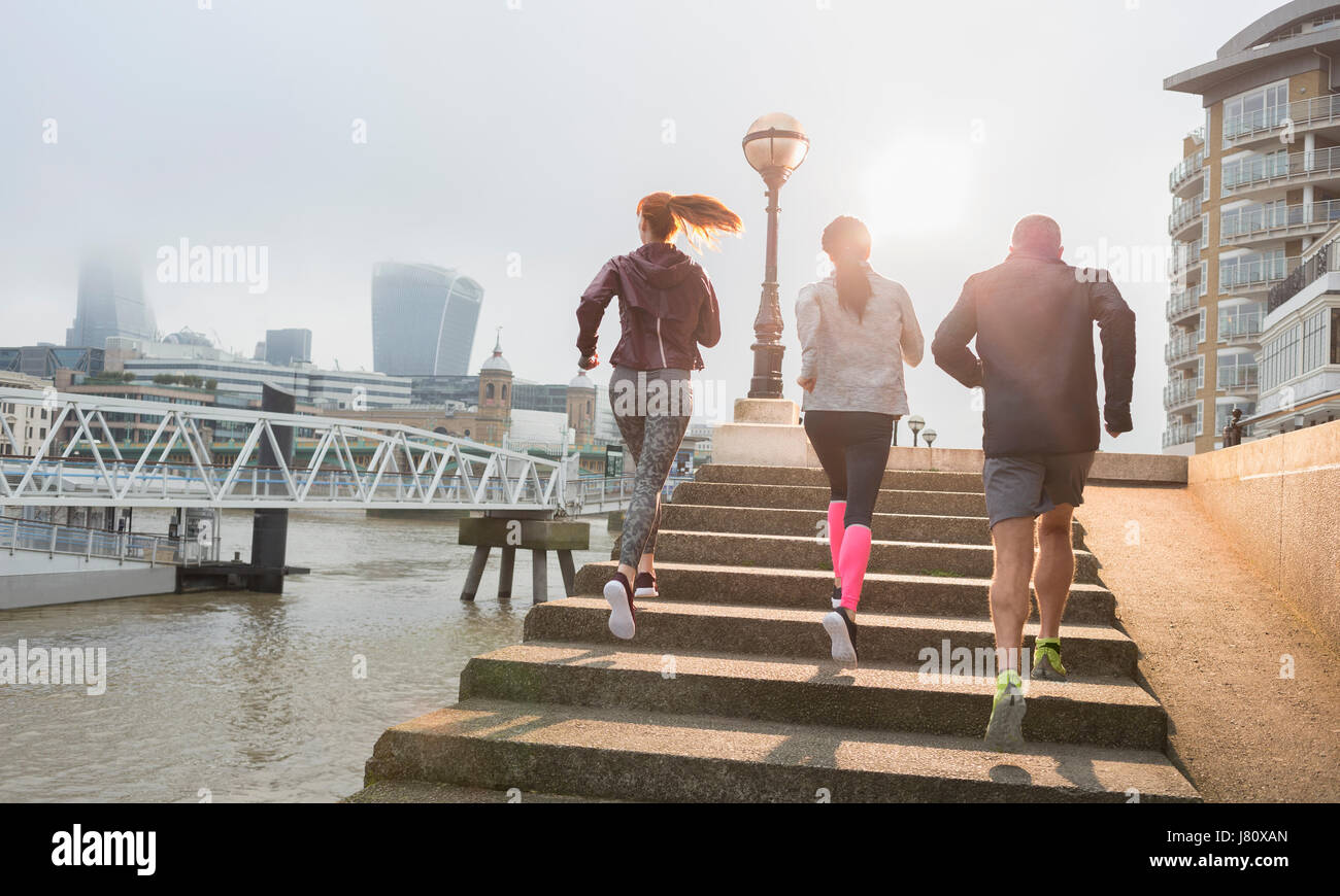 Runners running up sunny urban waterfront steps Stock Photo - Alamy