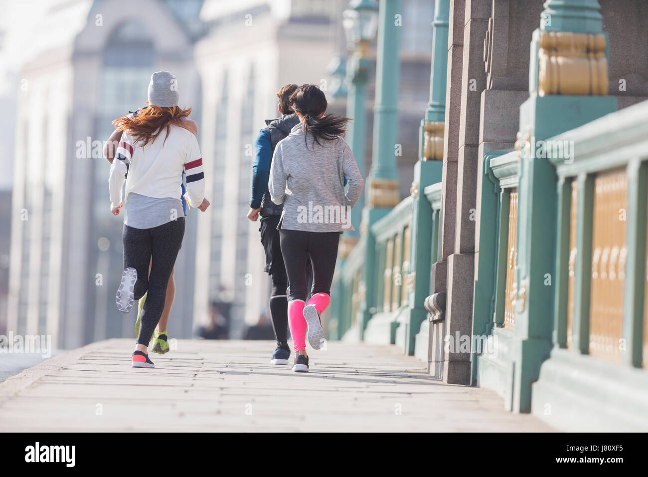 Runners running on sunny urban sidewalk Stock Photo - Alamy