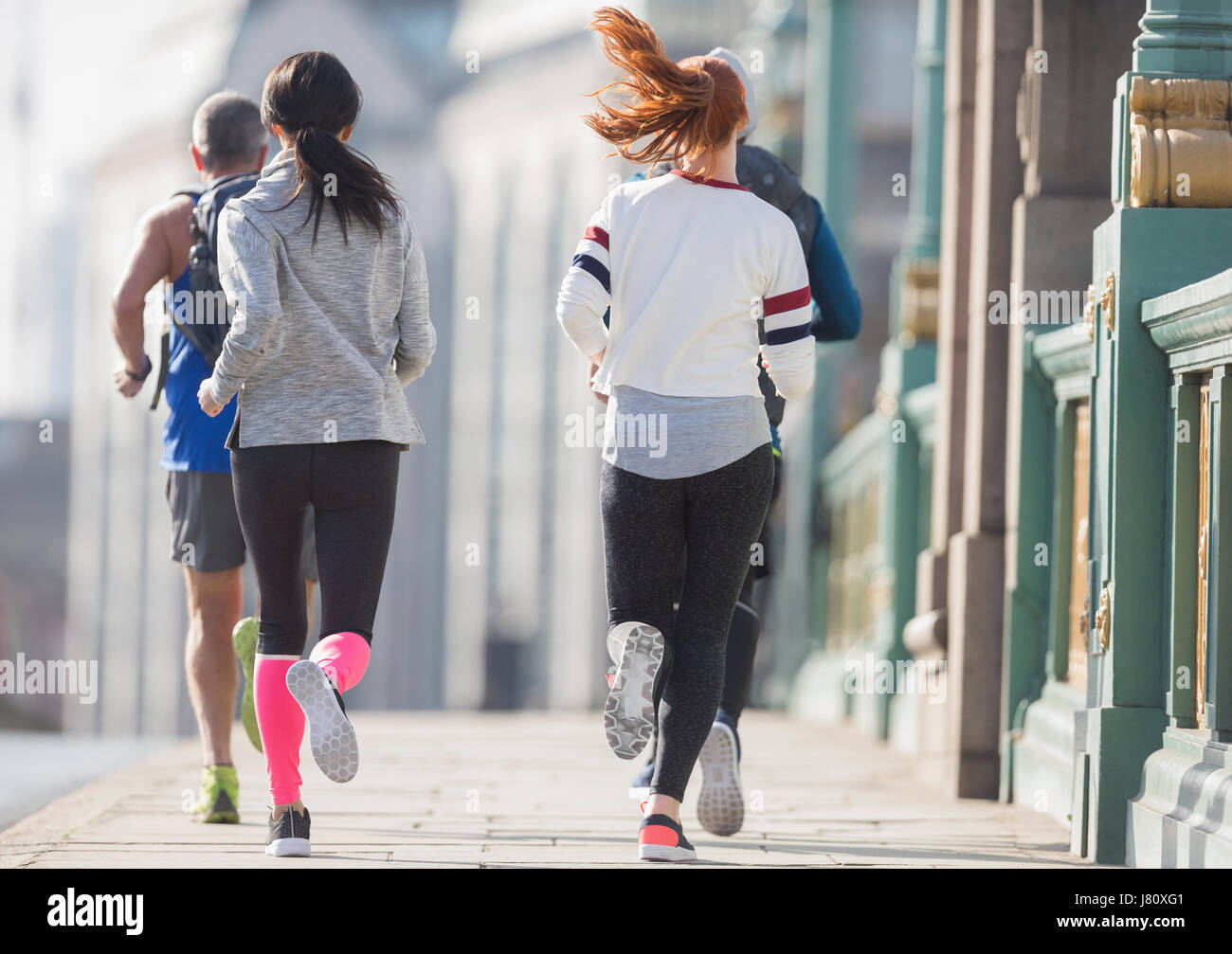 Runners running on sunny urban sidewalk Stock Photo - Alamy