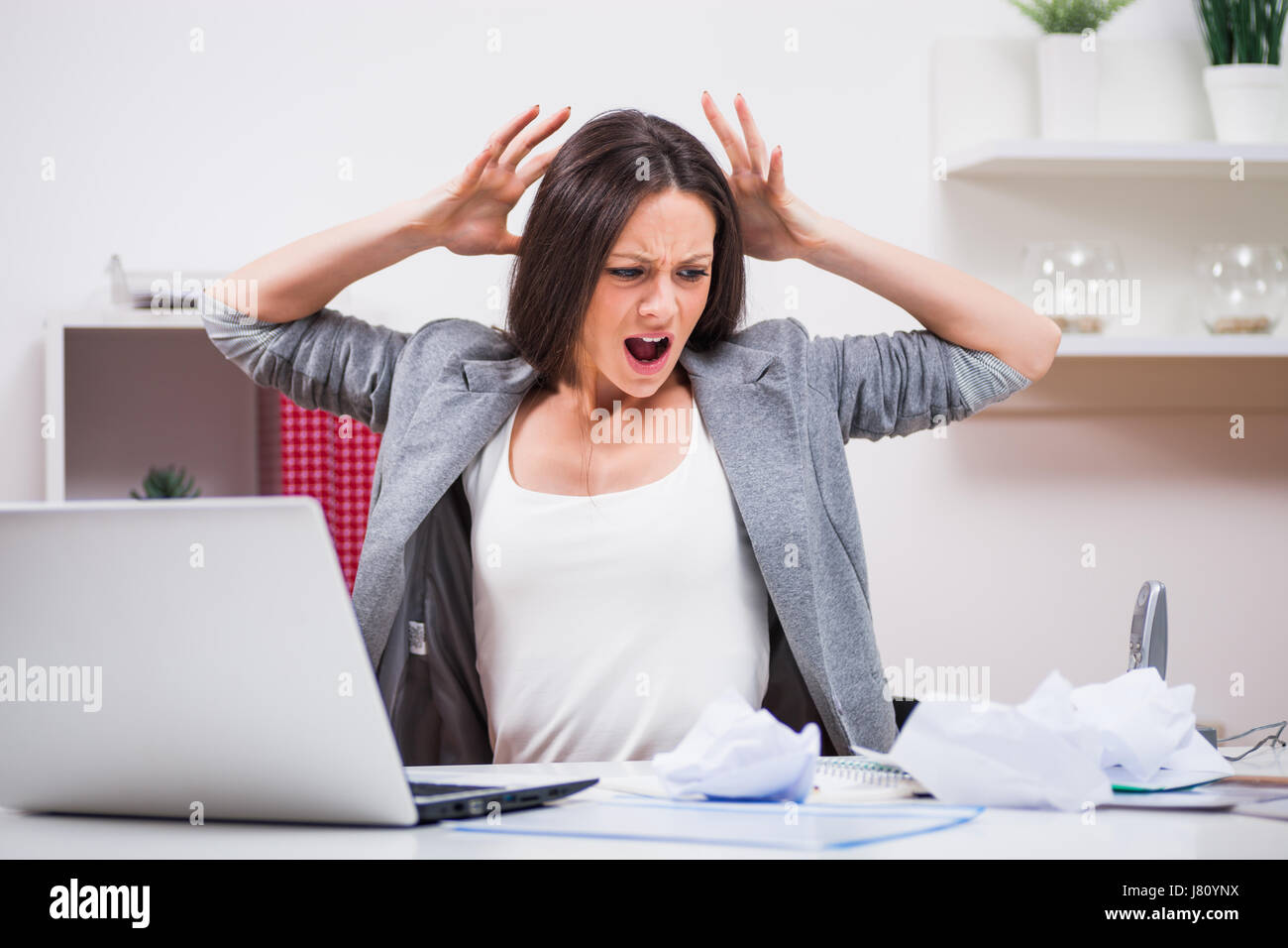 Young businesswoman is angry because she is tired of work Stock Photo ...