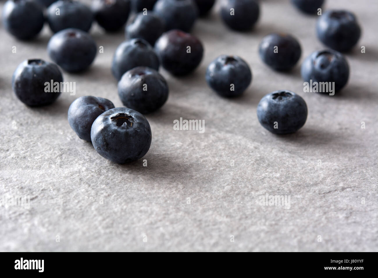 Blueberries on gray stone Stock Photo - Alamy