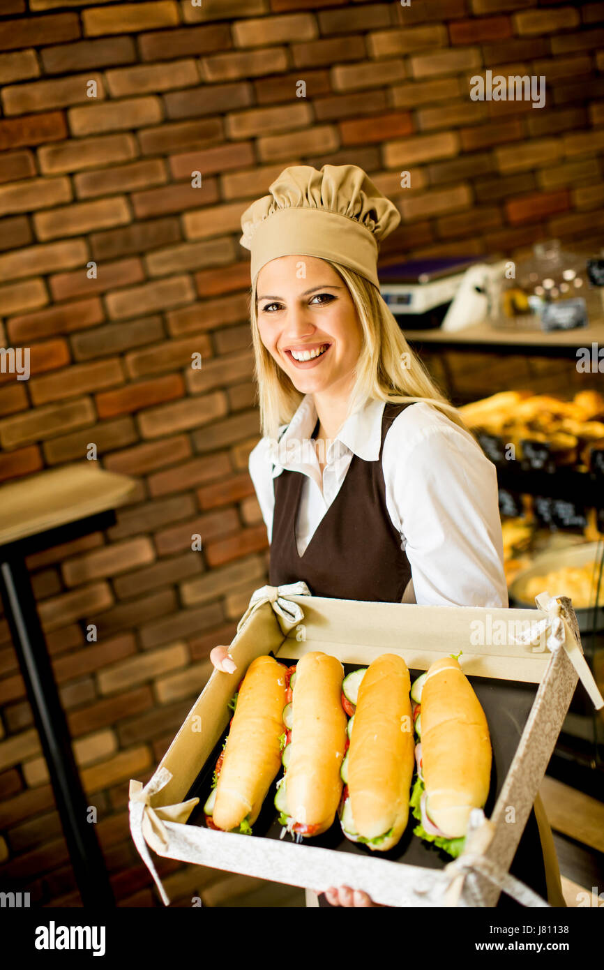 Beautiful female bakery posing with various types of sandwiches in the ...