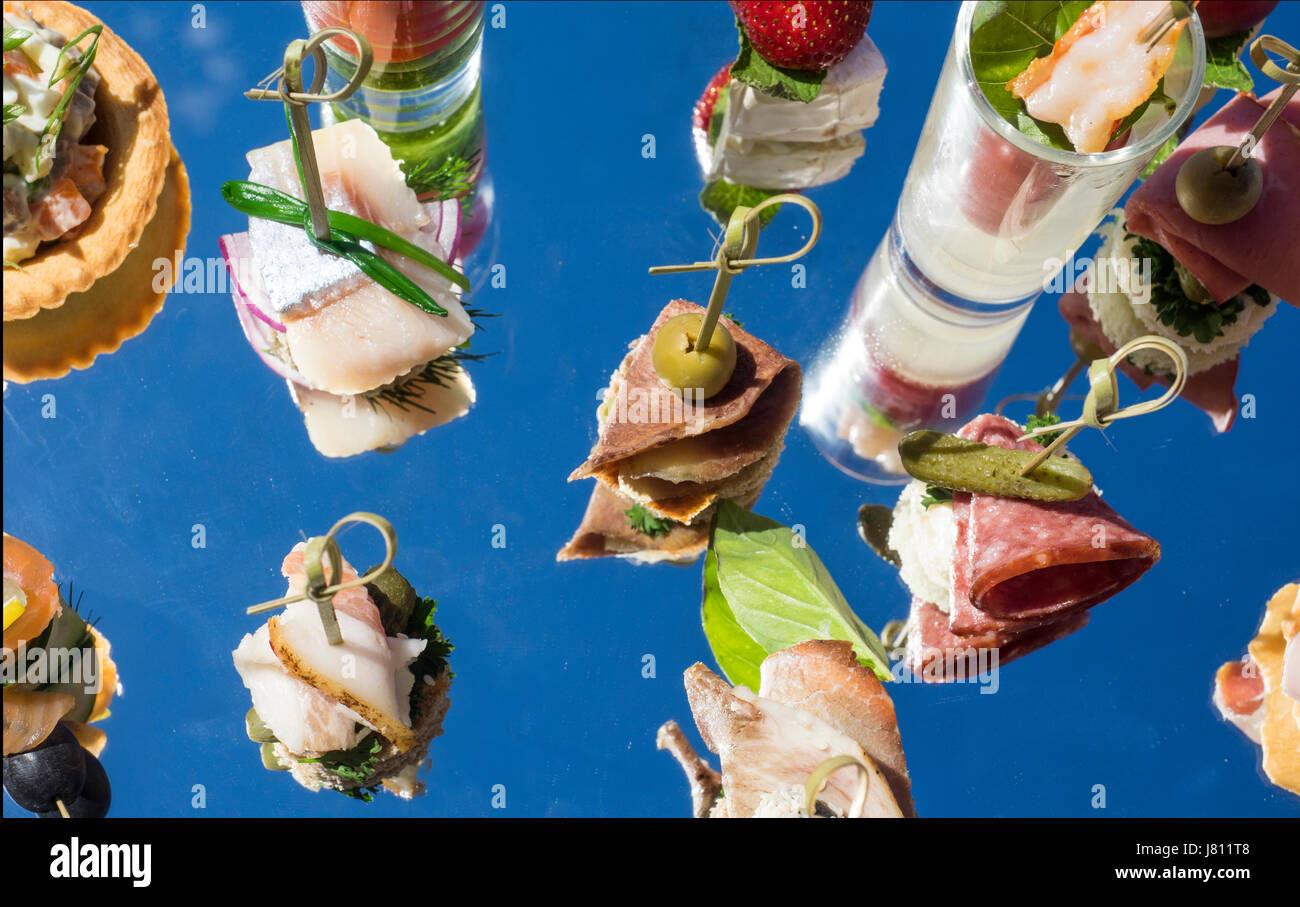 Set of different canapes and snacks served on a platter with a mirror ...