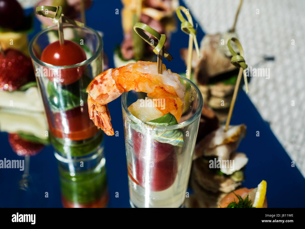 Set of different canapes and snacks served on a platter with a mirror ...