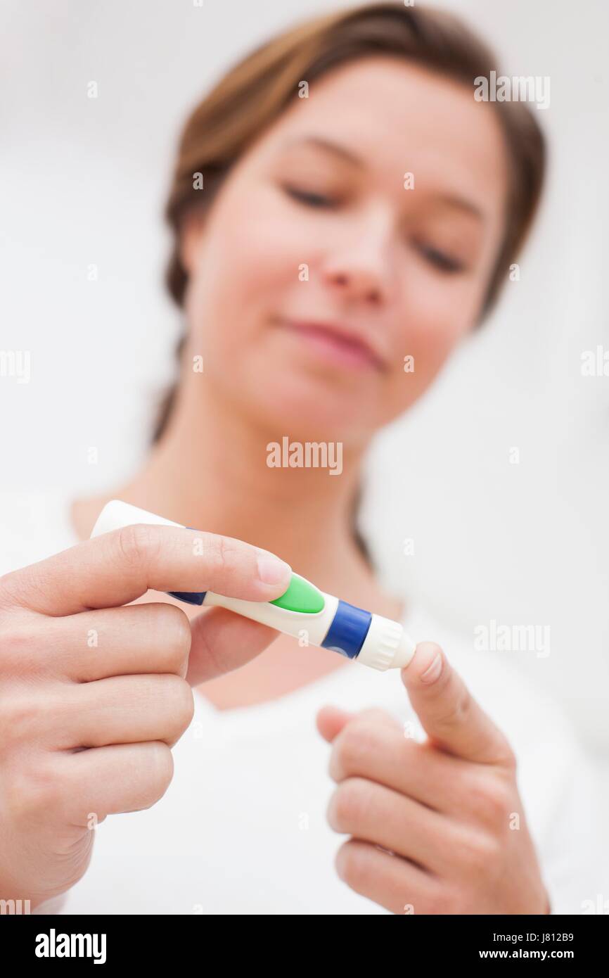 Woman doing finger prick test for blood glucose Stock Photo - Alamy