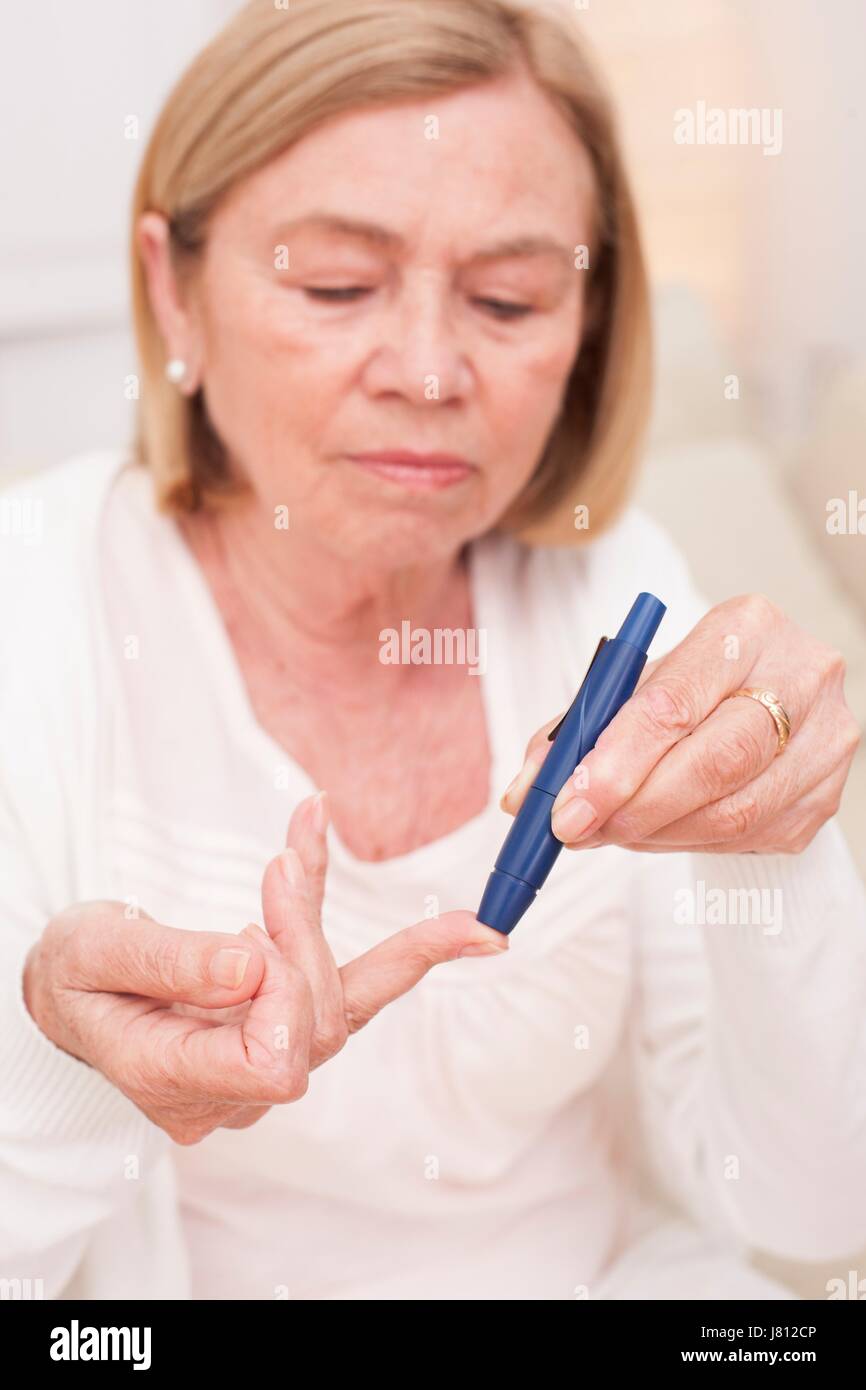 Woman doing finger prick test for blood glucose Stock Photo - Alamy