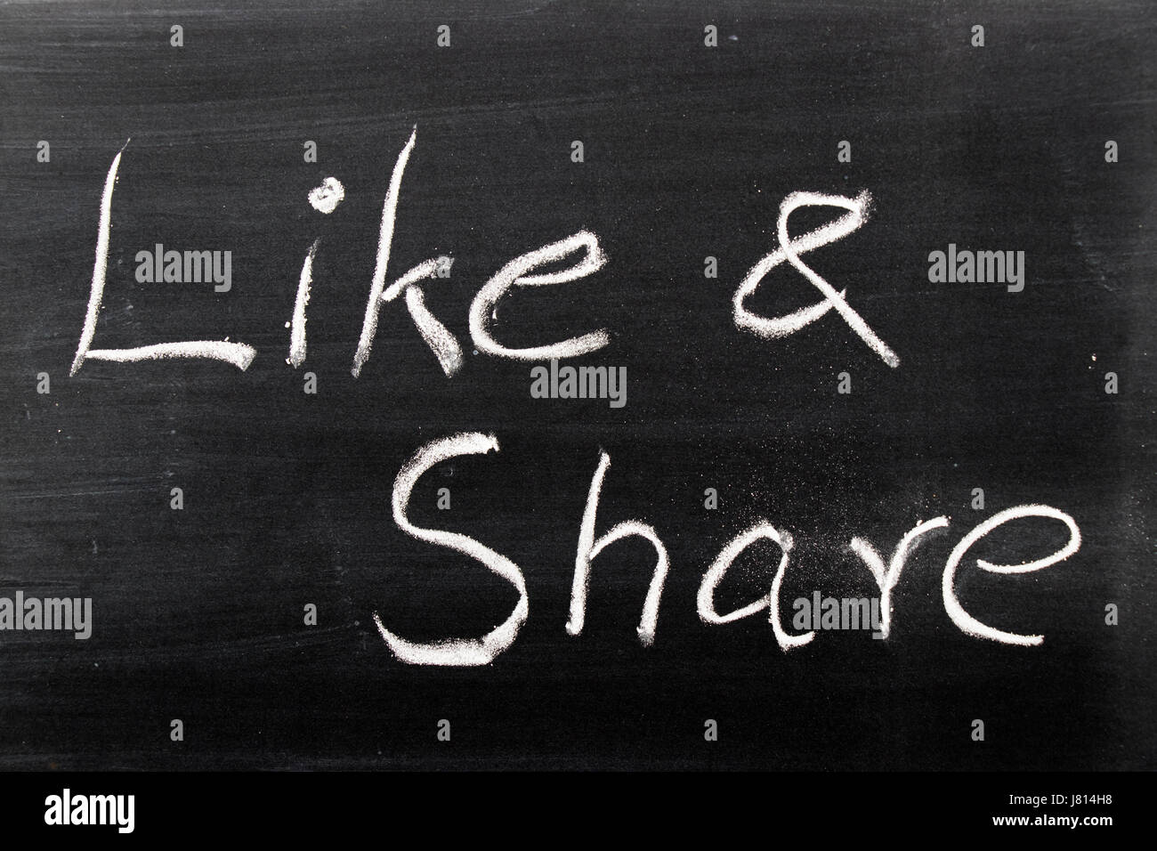 Like & Share wording, hand writing by chalk on black board background ...
