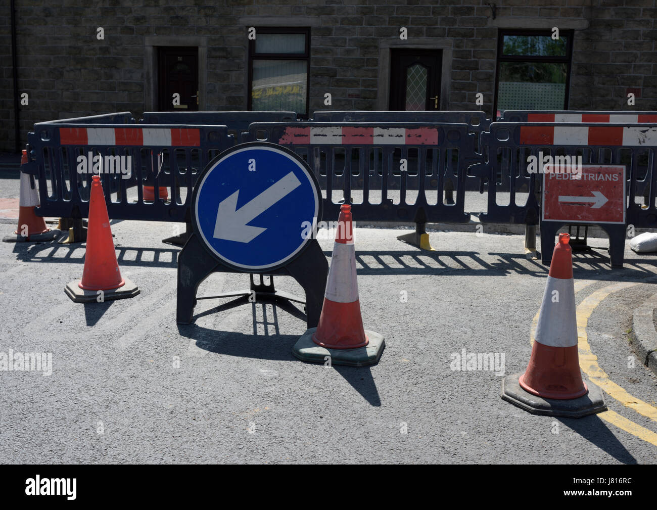 Road works, blue keep left sign with white arrow, pedestrians keep ...