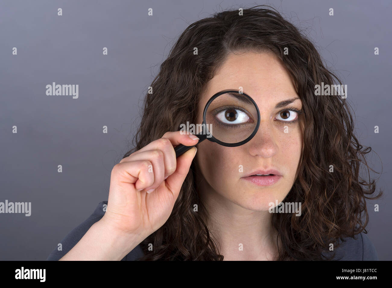 woman with magnifying glass in front of face Stock Photo - Alamy