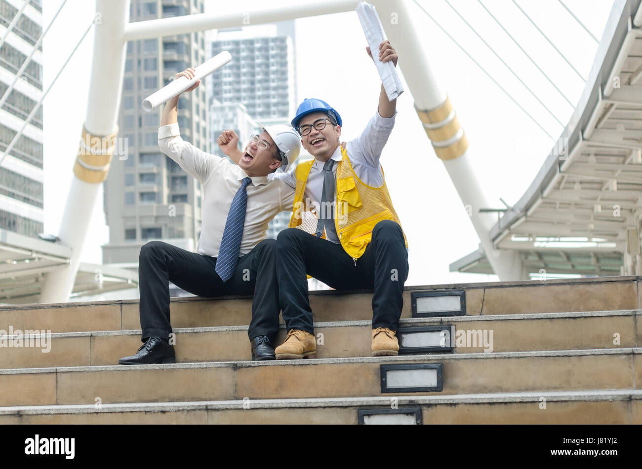 Success business concept. Two asian architects keeping hands up with ...