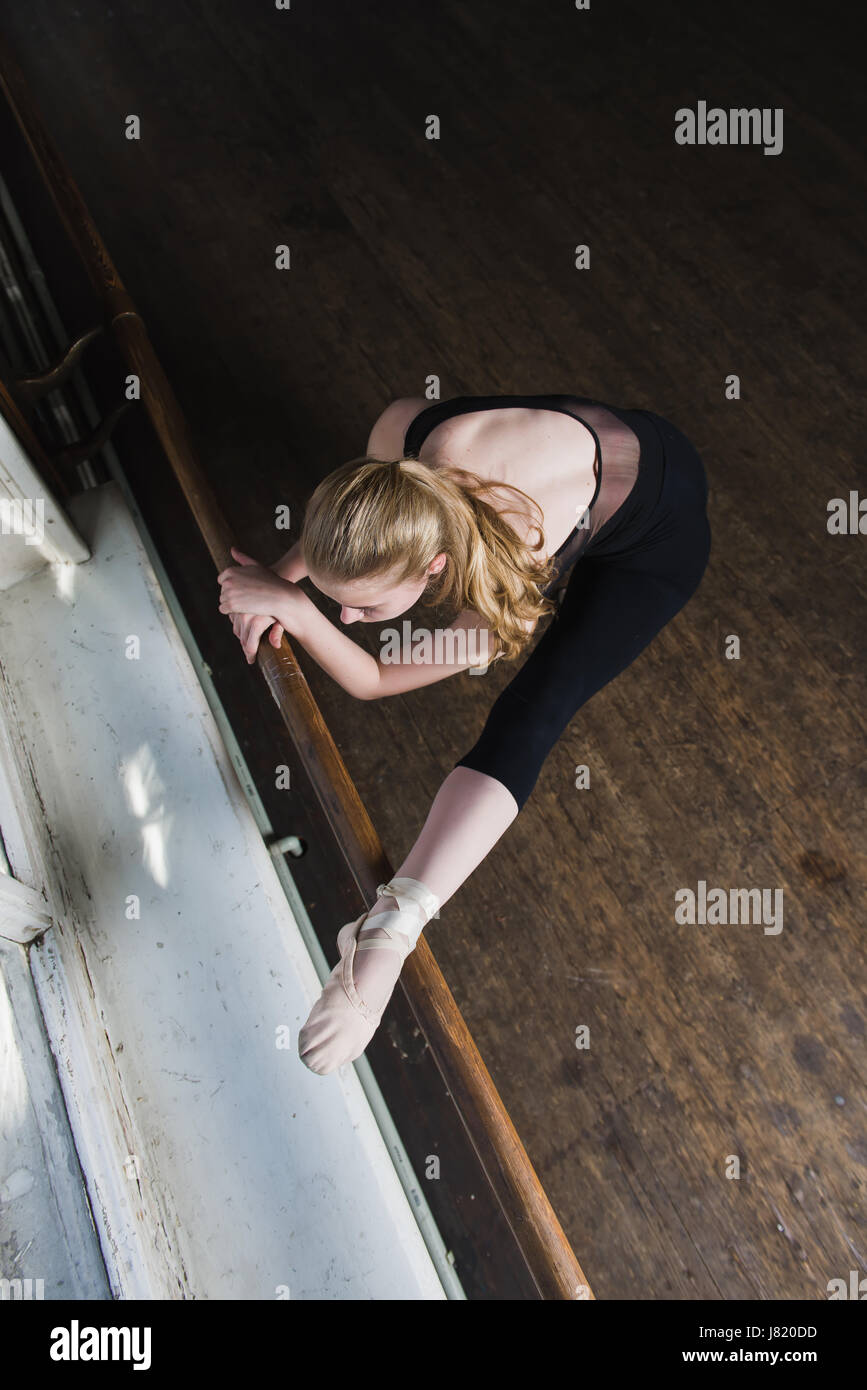 Female ballet dancer stretching at ballet barre. Top shot Stock Photo ...
