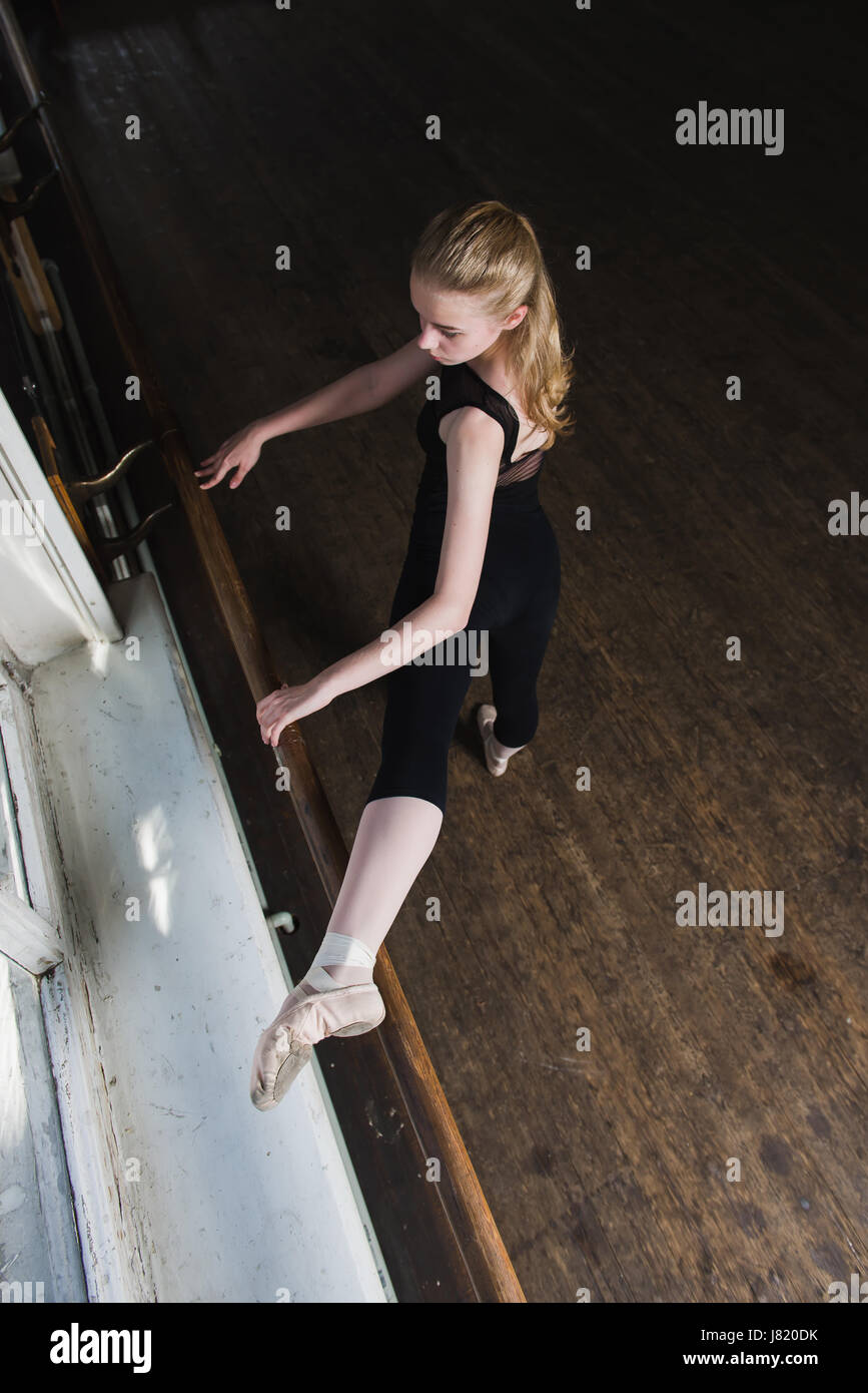 Female ballet dancer stretching at ballet barre. Top shot Stock Photo ...