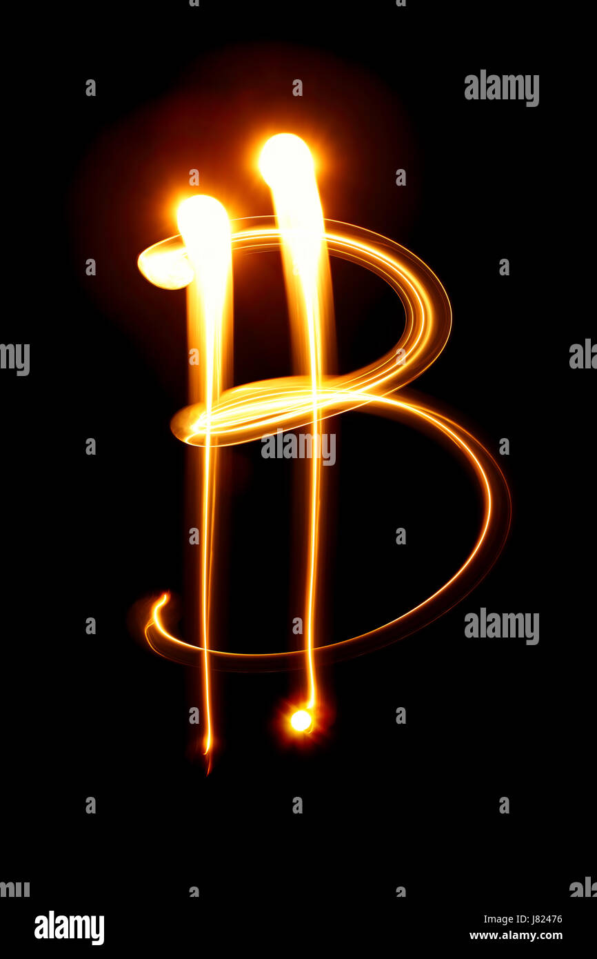 Bitcoin sign over black background - light painting Stock Photo - Alamy