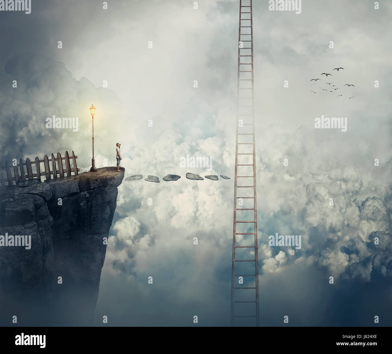 Imaginary view as a young boy stand on the peak of a cliff above clouds ...