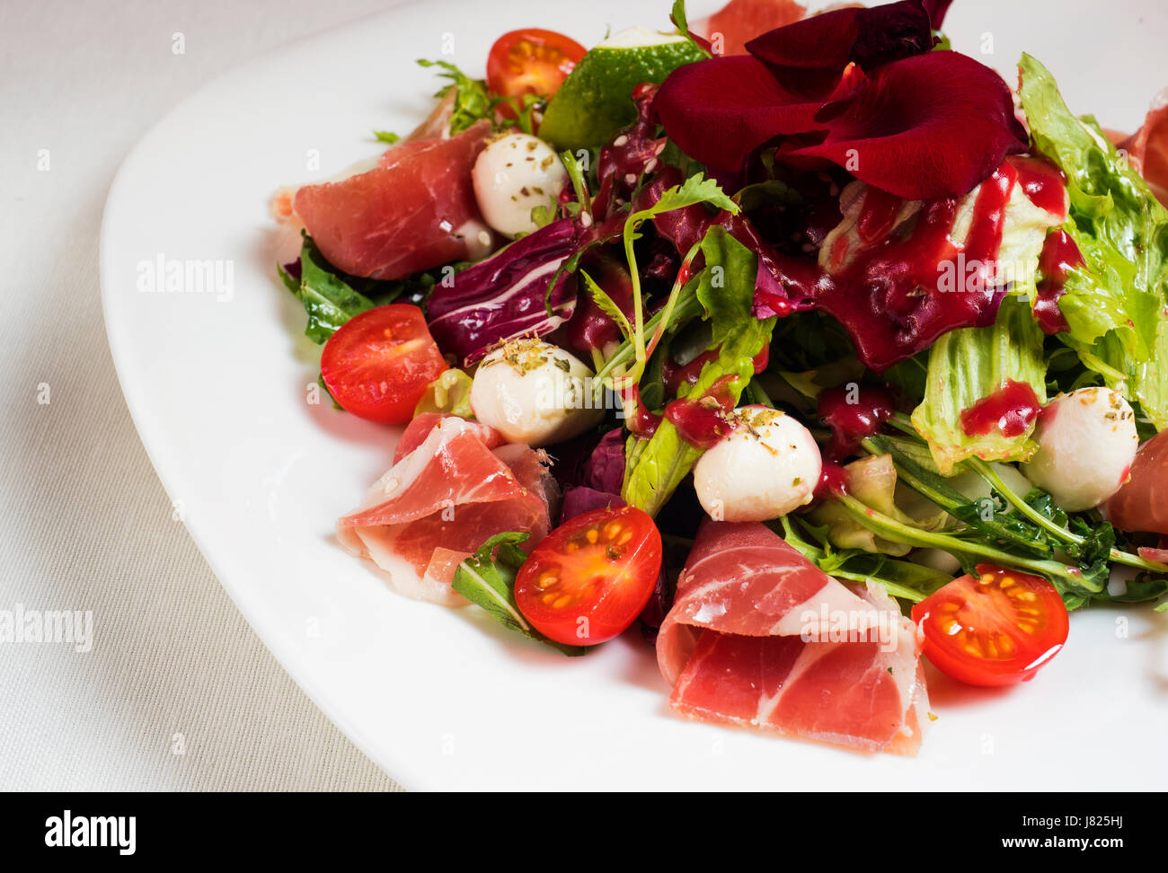 Mix of salads with prosciutto and mini mozzarella Stock Photo - Alamy