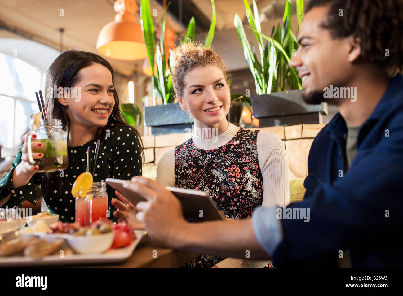 happy friends eating and drinking at restaurant Stock Photo - Alamy