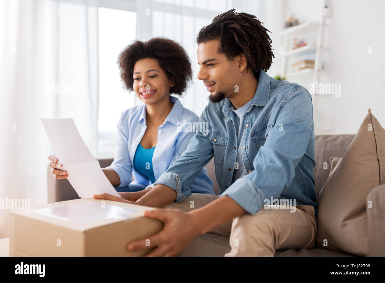 happy couple with parcel box and paper form home Stock Photo - Alamy