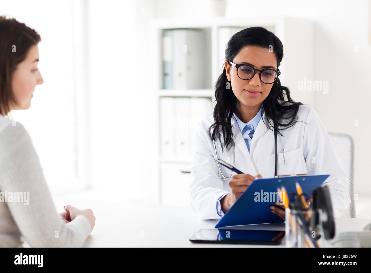 doctor with clipboard and woman at hospital Stock Photo - Alamy