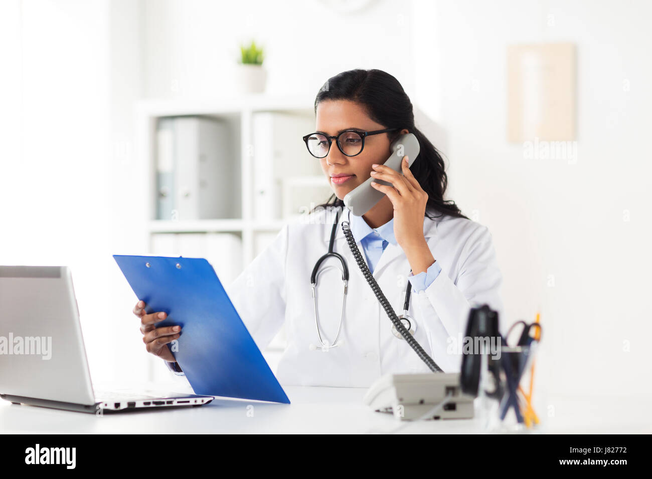 doctor with clipboard calling on phone at hospital Stock Photo - Alamy