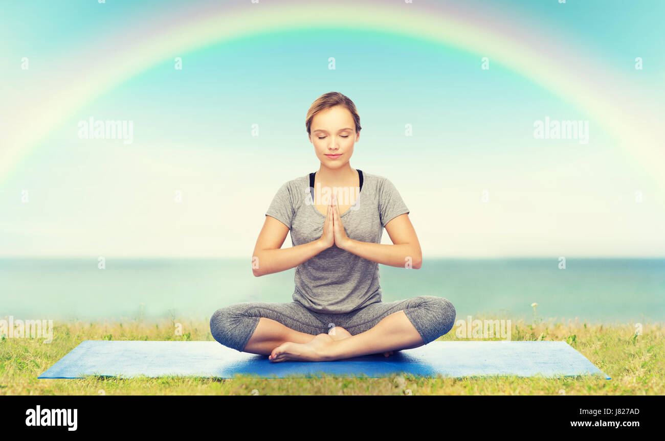 woman making yoga meditation in lotus pose on mat Stock Photo - Alamy
