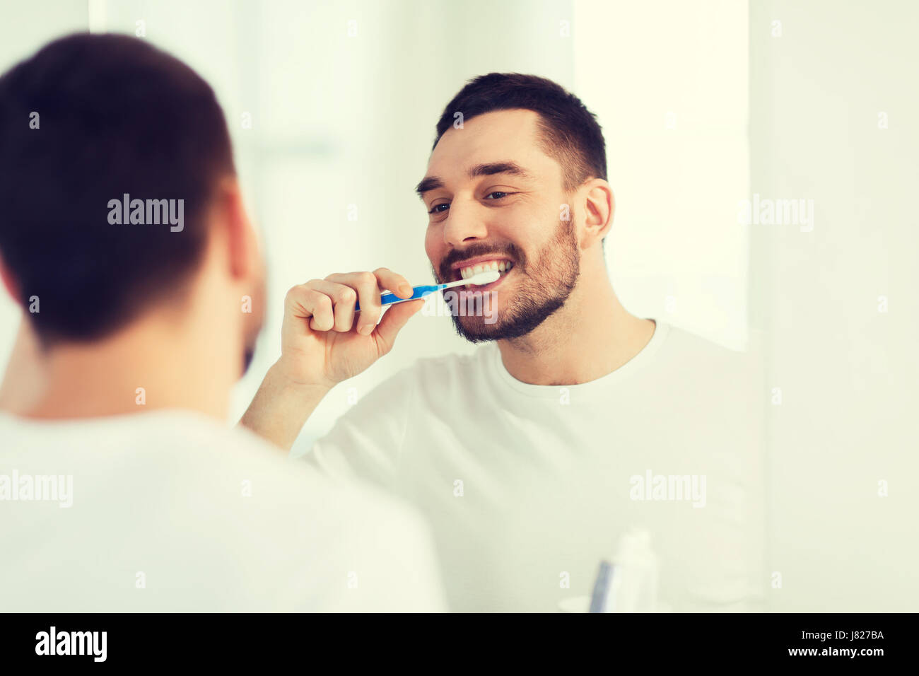 man with toothbrush cleaning teeth at bathroom Stock Photo - Alamy