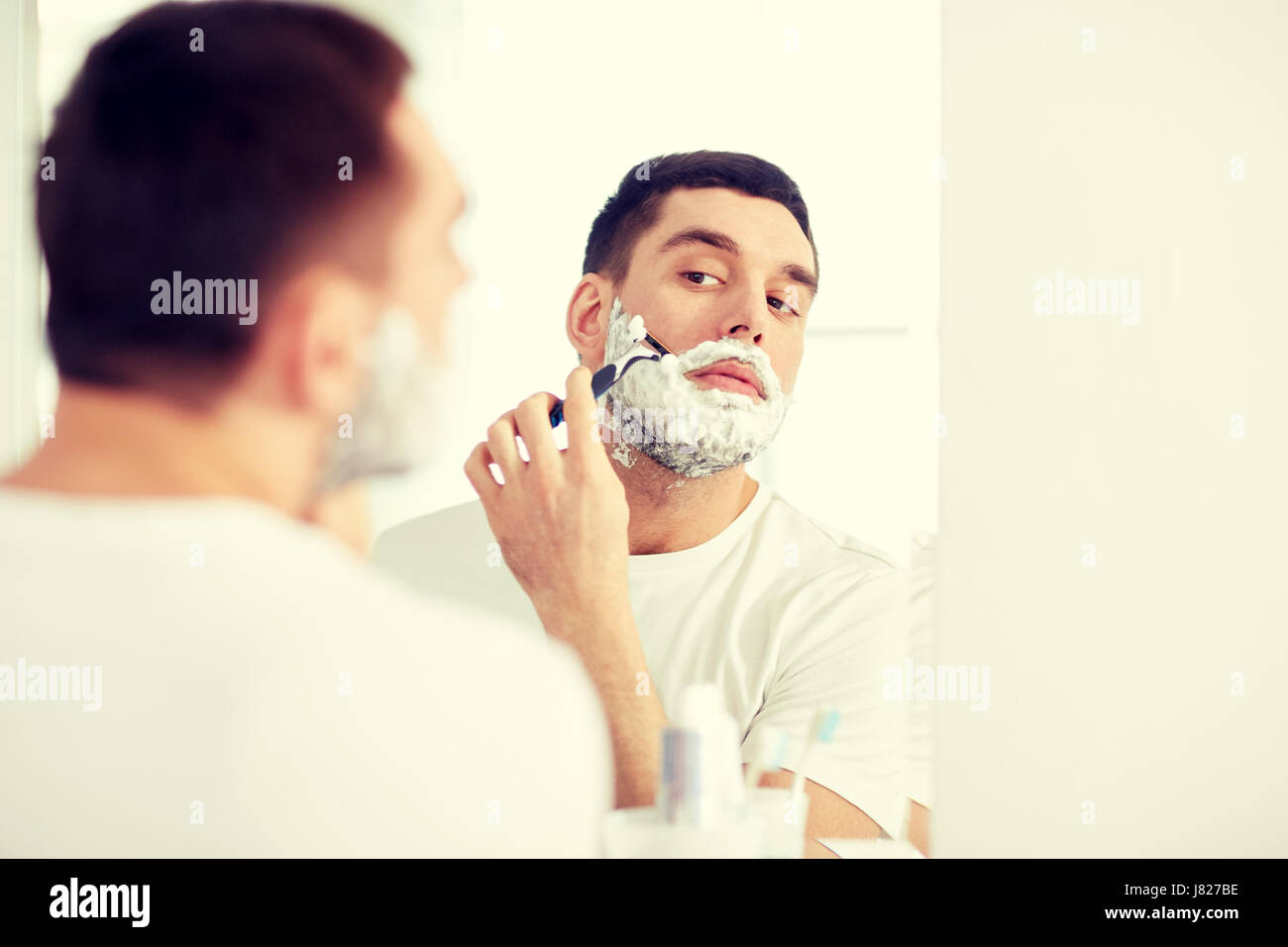 man shaving beard with razor blade at bathroom Stock Photo - Alamy