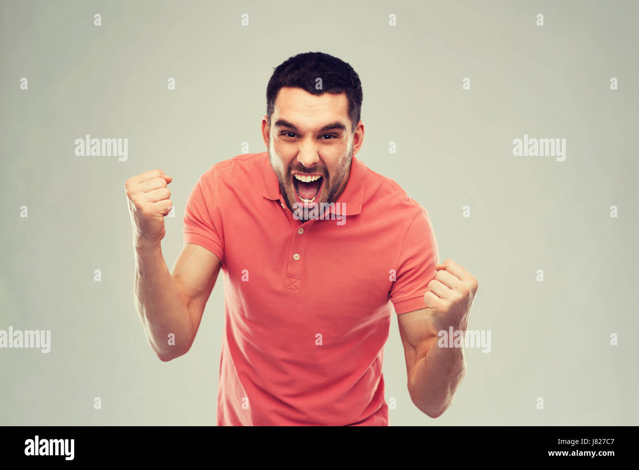 happy man celebrating victory over gray background Stock Photo - Alamy