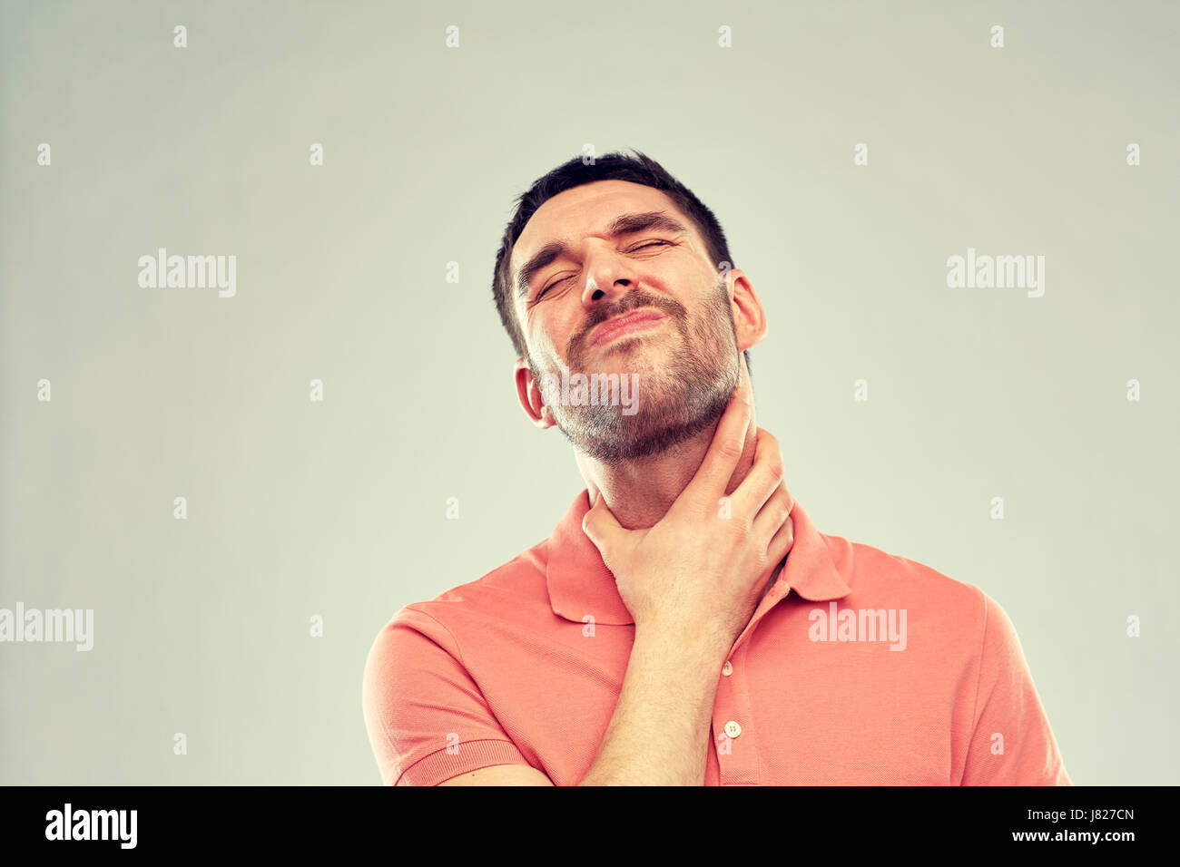 man touching neck and suffering from throat pain Stock Photo - Alamy