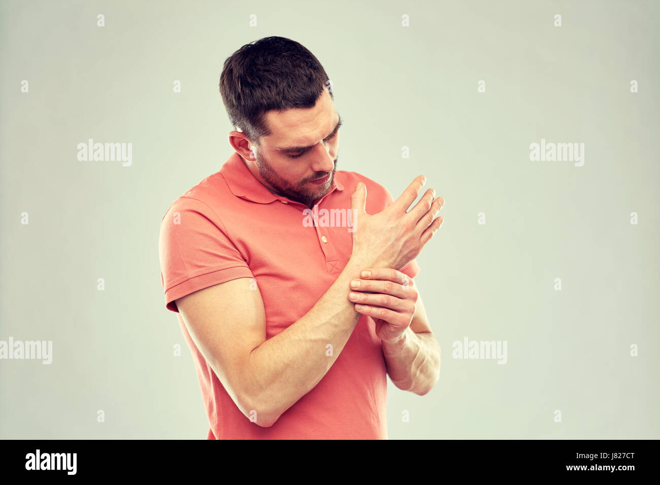 unhappy man suffering from pain in hand Stock Photo - Alamy