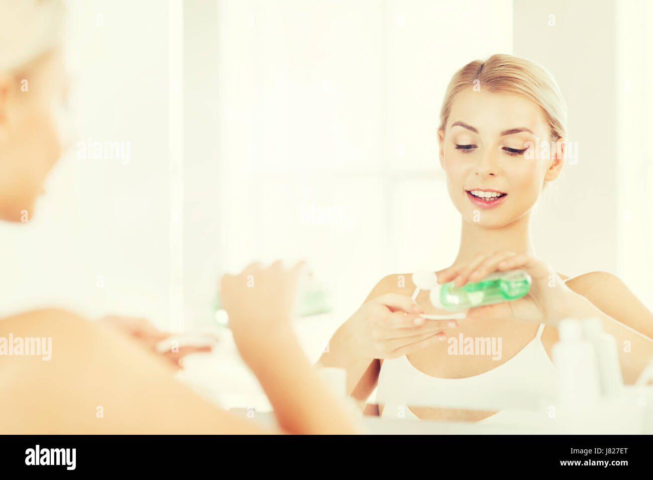young woman with lotion washing face at bathroom Stock Photo - Alamy
